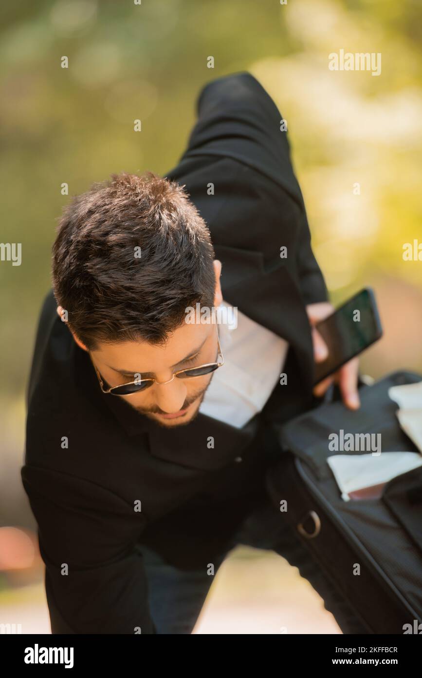 Close up of a businessman trying to pick up something Stock Photo - Alamy