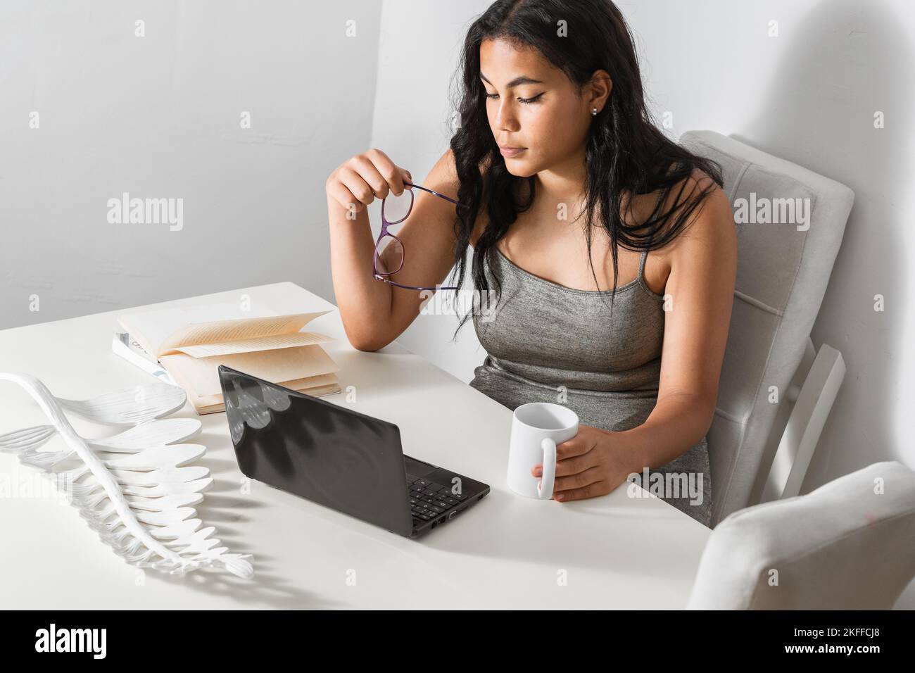 beautiful brunette woman doing her chores and homework sitting in the ...