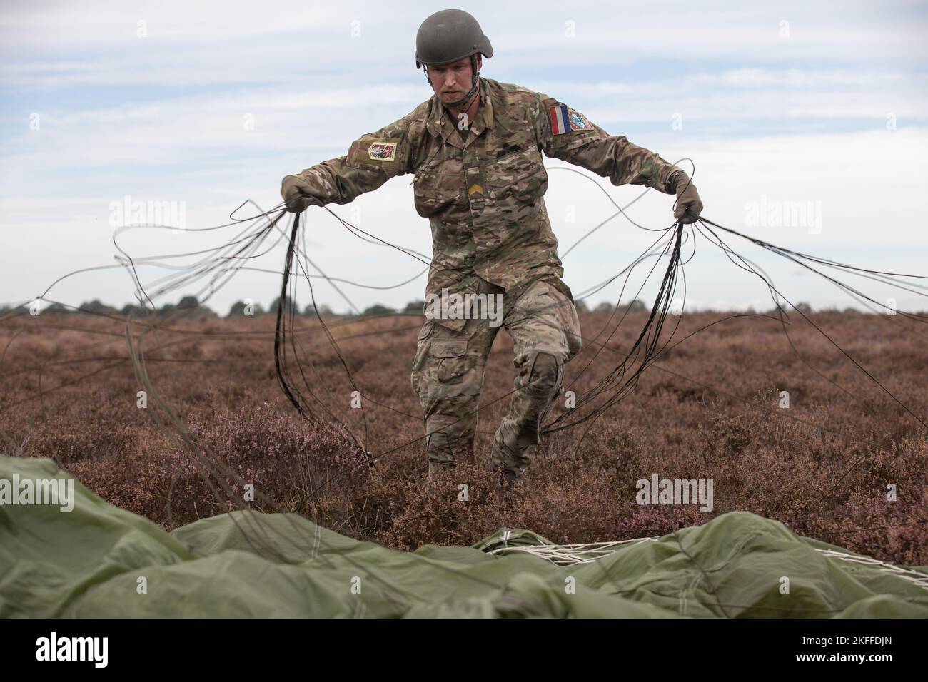 A Dutch Paratrooper packs away his German T-10 parachute after landing ...