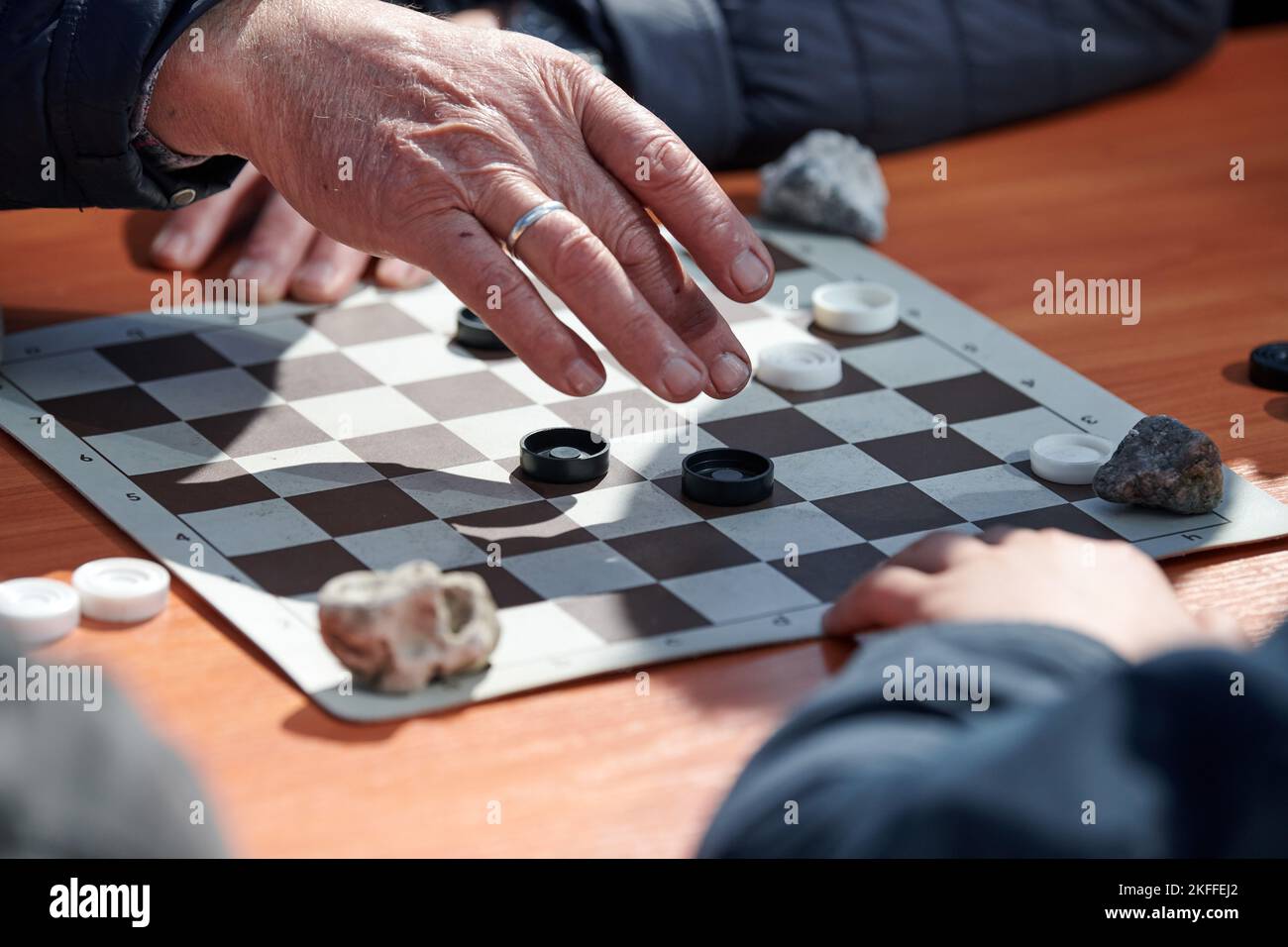 Outdoor checkers tournament on paper checkerboard on table, close up ...
