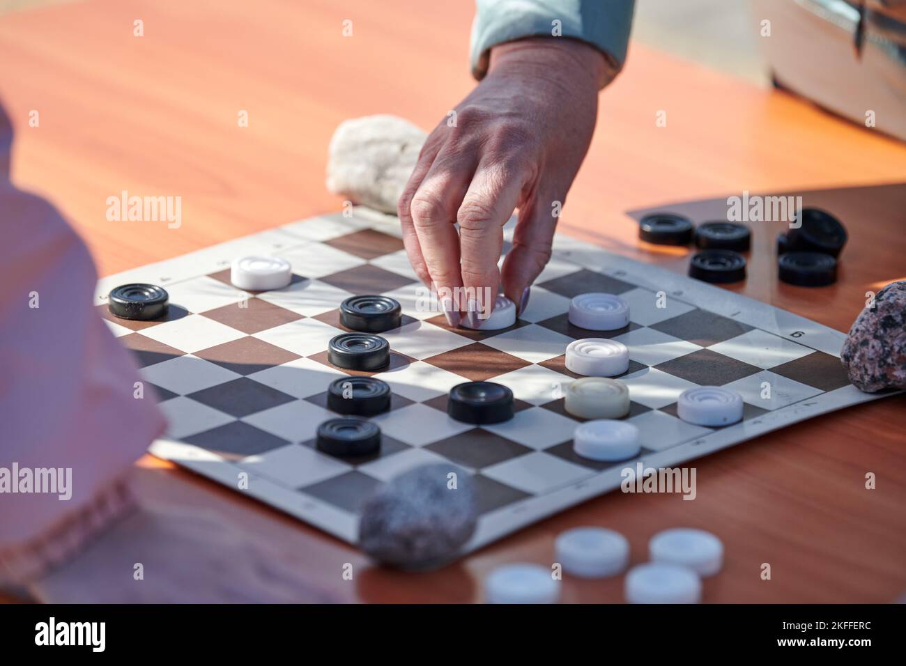 Outdoor checkers tournament on paper checkerboard on table, close up ...