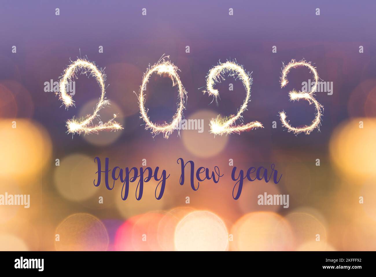 Happy new year 2023 written with sparkes on blurred bokeh lights background, holiday greeting ...