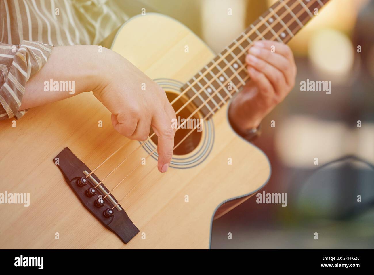 Man playing acoustic bass guitar at outdoor event, close up view to ...