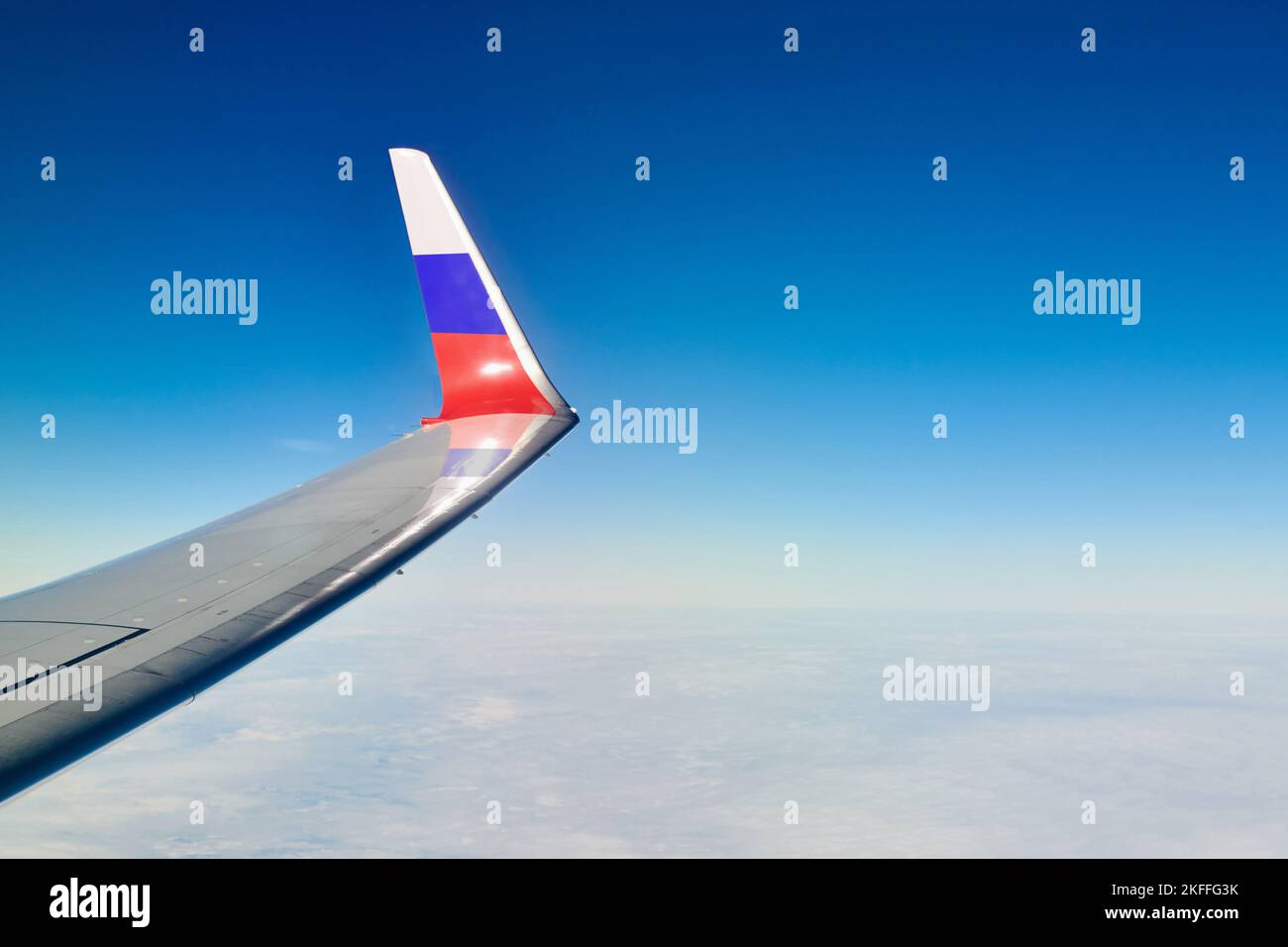 Airplane wing with Russian flag colors over clouds aerial top view from ...