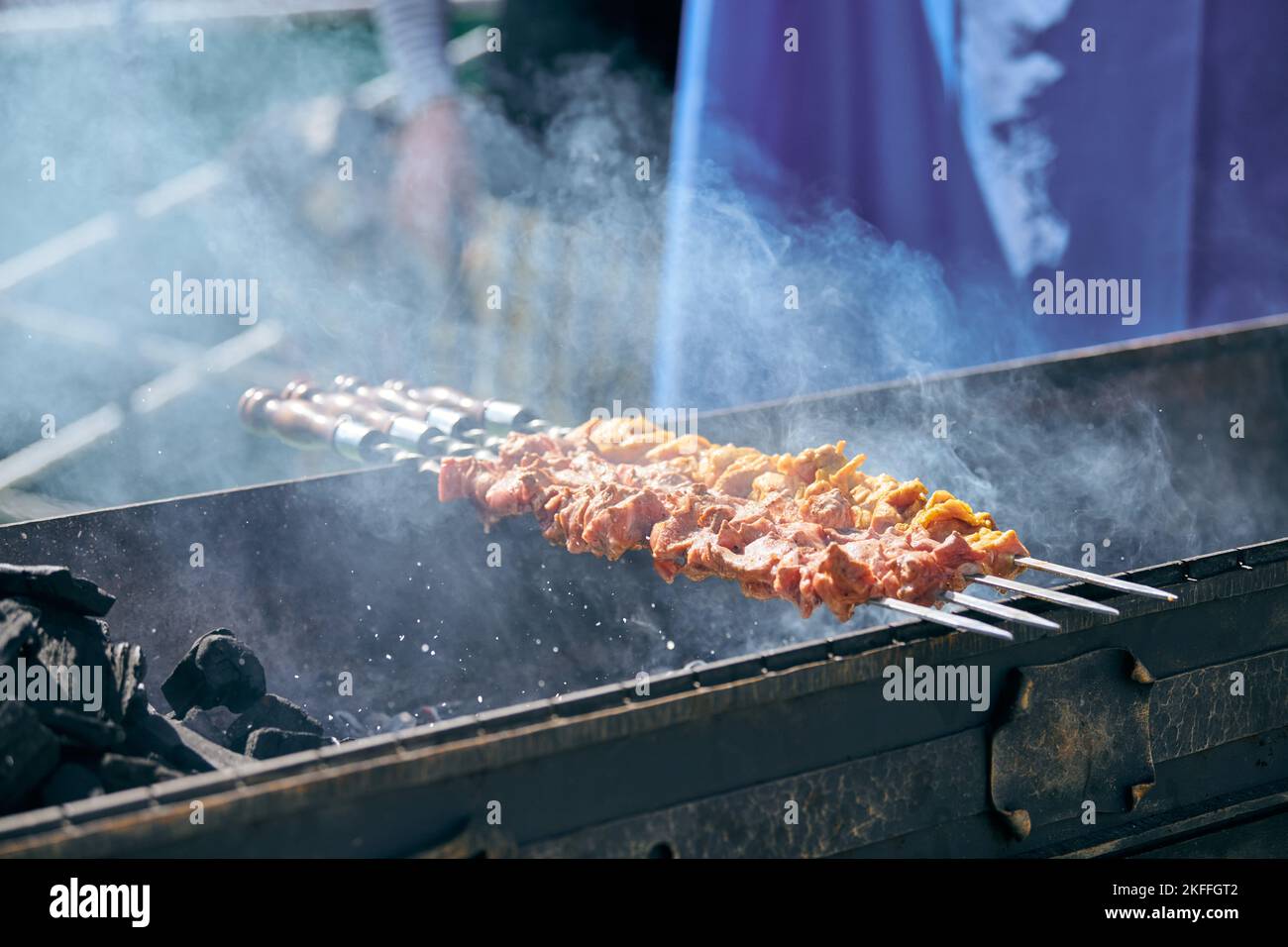 Cooking pork barbecue with skewers cubes of meat on BBQ grill ...