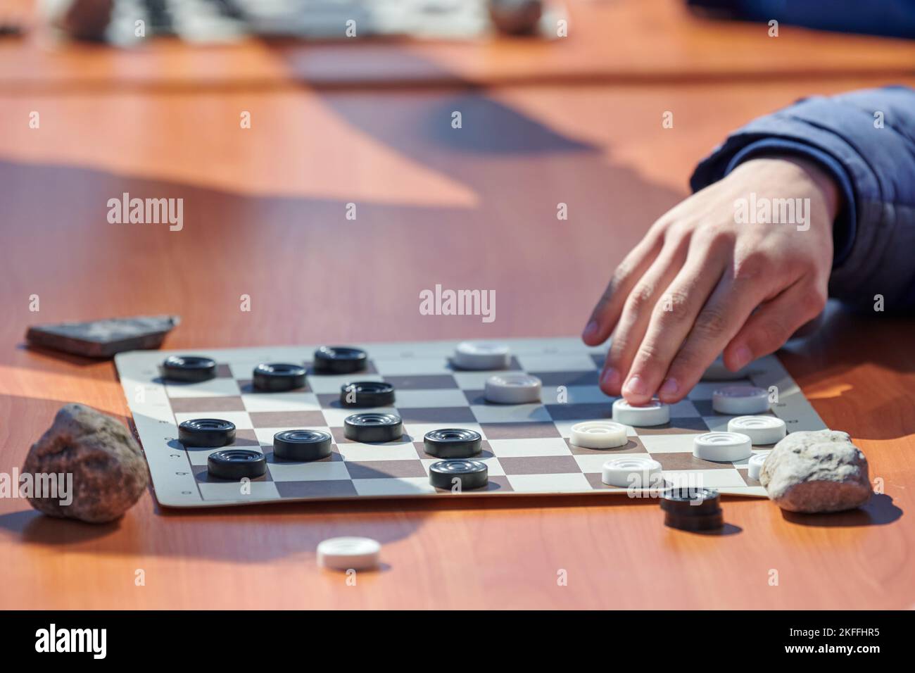 Outdoor checkers tournament on paper checkerboard on table, close up ...