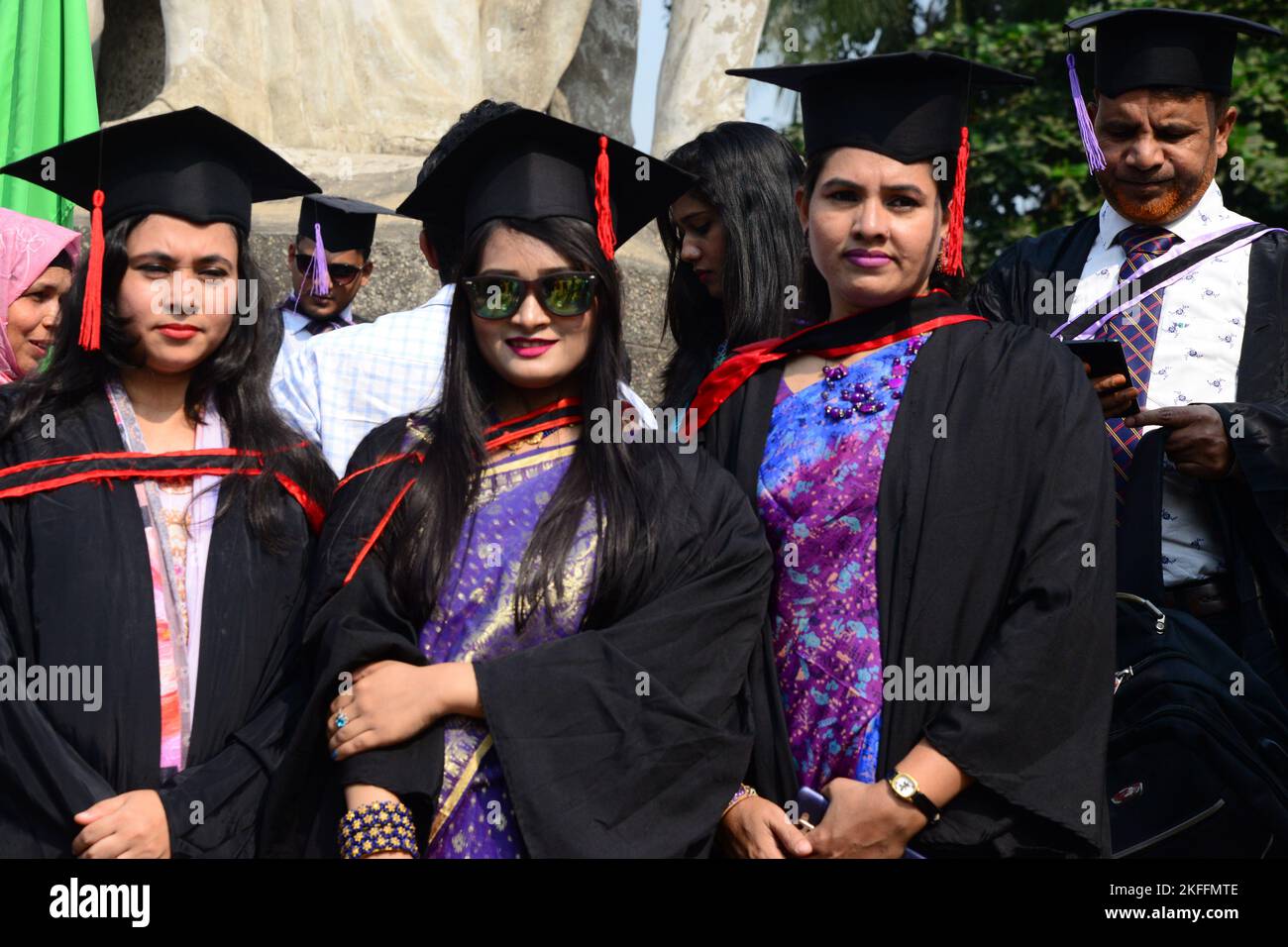 A group of graduates expressing their delight in front of the sculpture ...