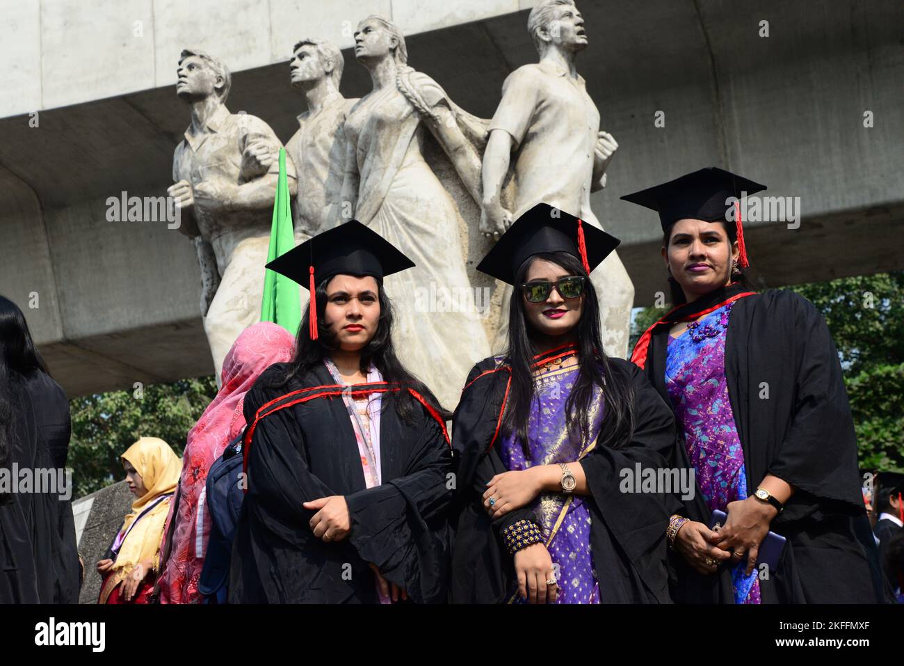 A group of graduates expressing their delight in front of the sculpture ...