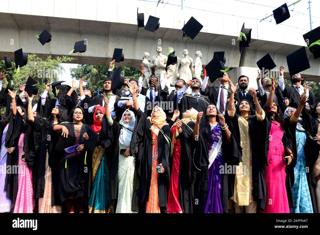 A group of graduates expressing their delight in front of the sculpture ...