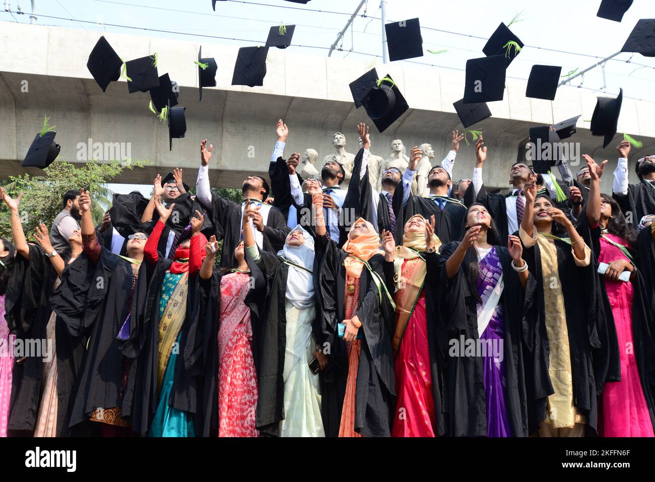A group of graduates expressing their delight in front of the sculpture ...
