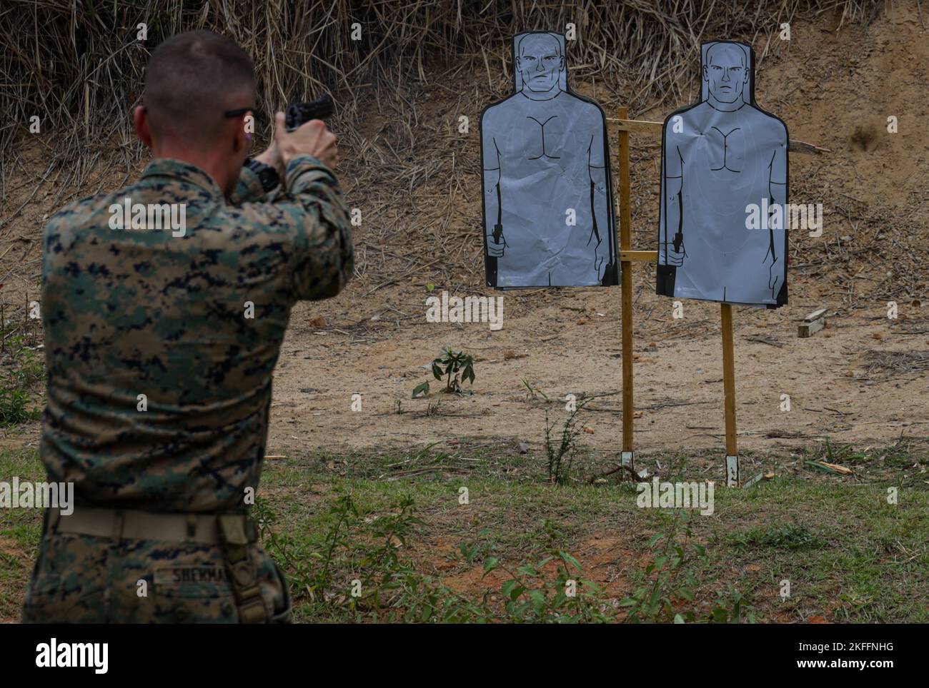 A U.S. Marine fires at a target using an M9 pistol during a pistol ...
