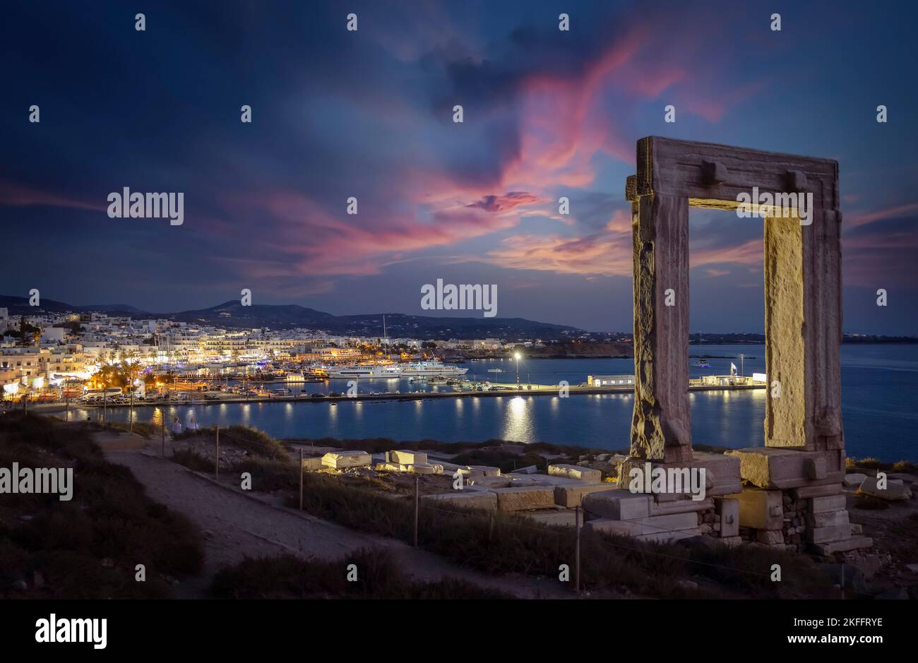 The famous Portara marble gate in front of the illuminated town of ...