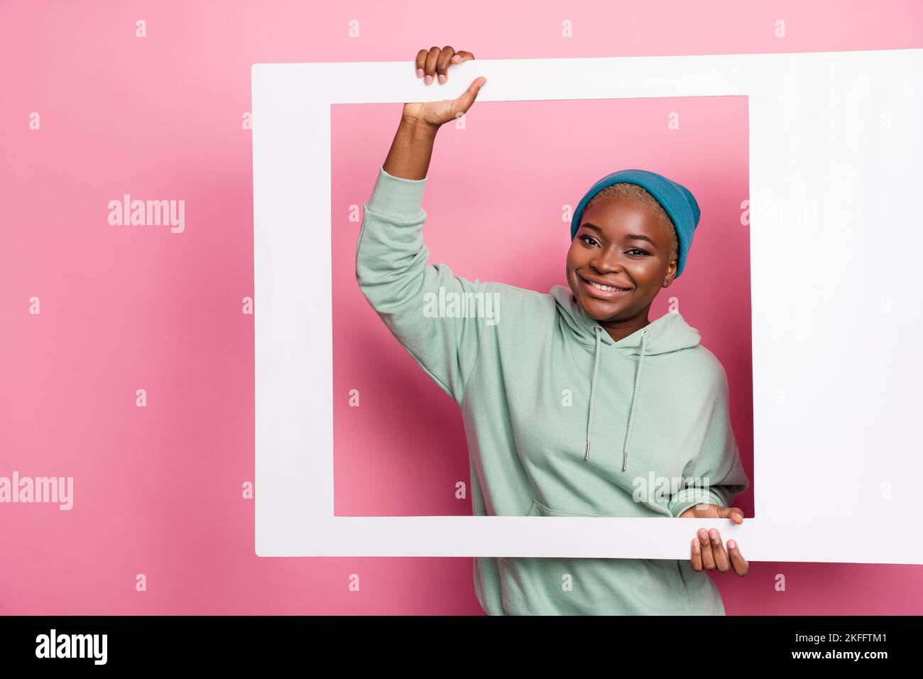 Portrait of young adorable girl holding big white polaroid frame ...