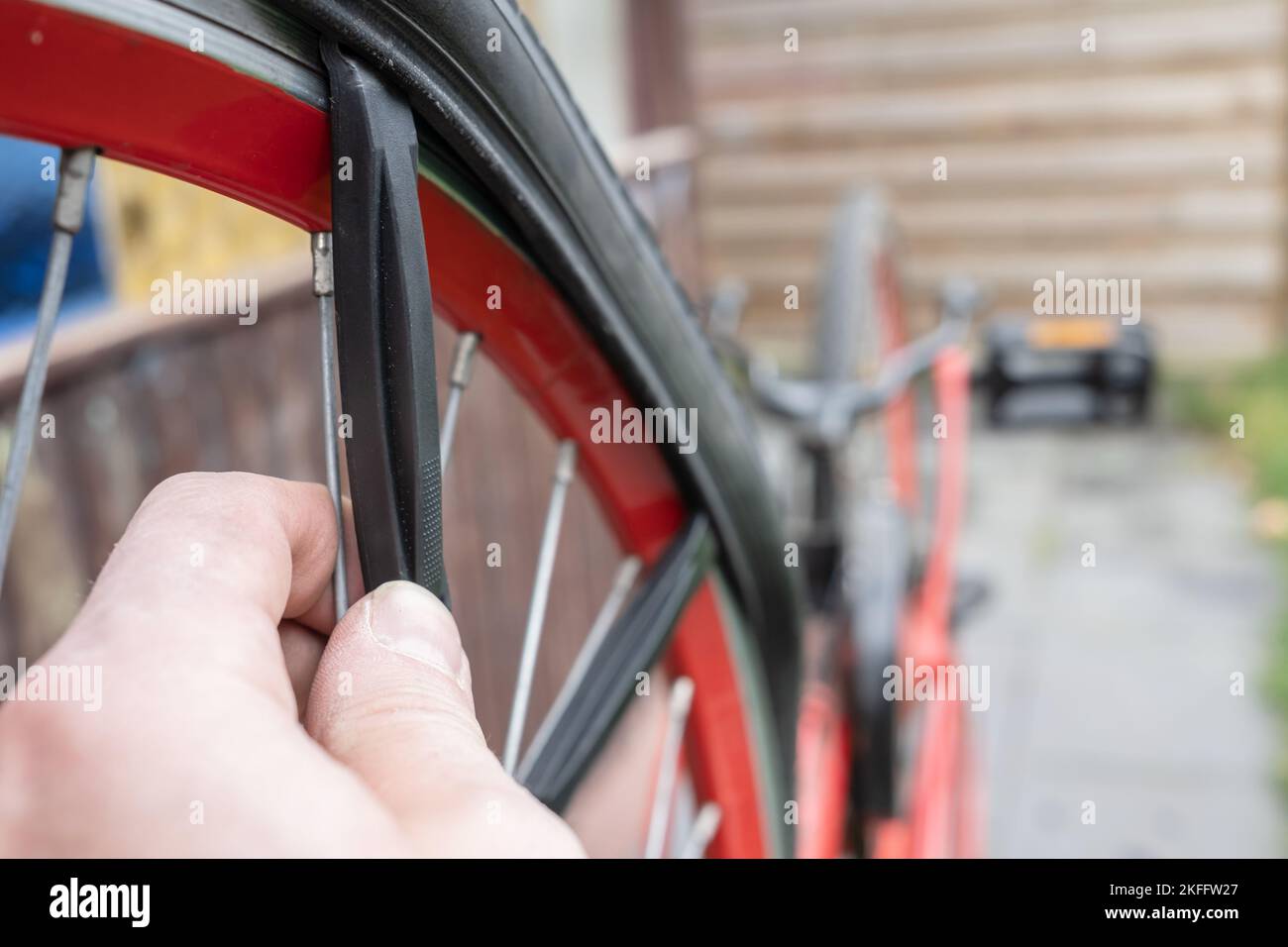 Repairing a punctured bicycle wheel. Cyclists hand removes the tire ...