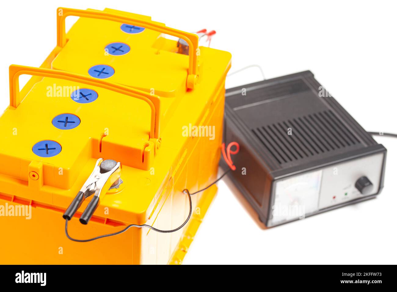 yellow car battery with car battery charger isolated on white ...