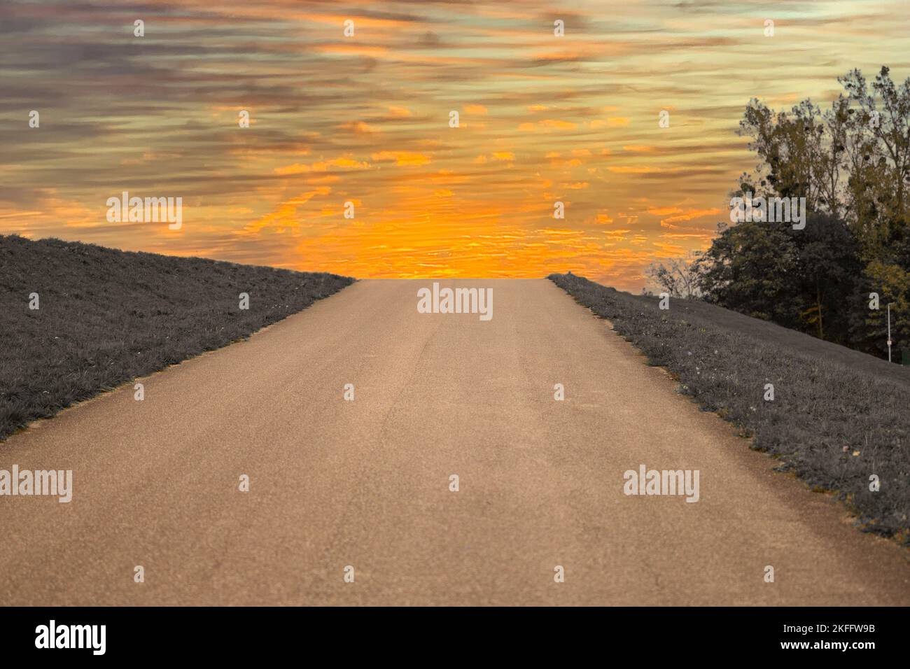 Totally empty road uphill, gray black grass on the sides and the ...