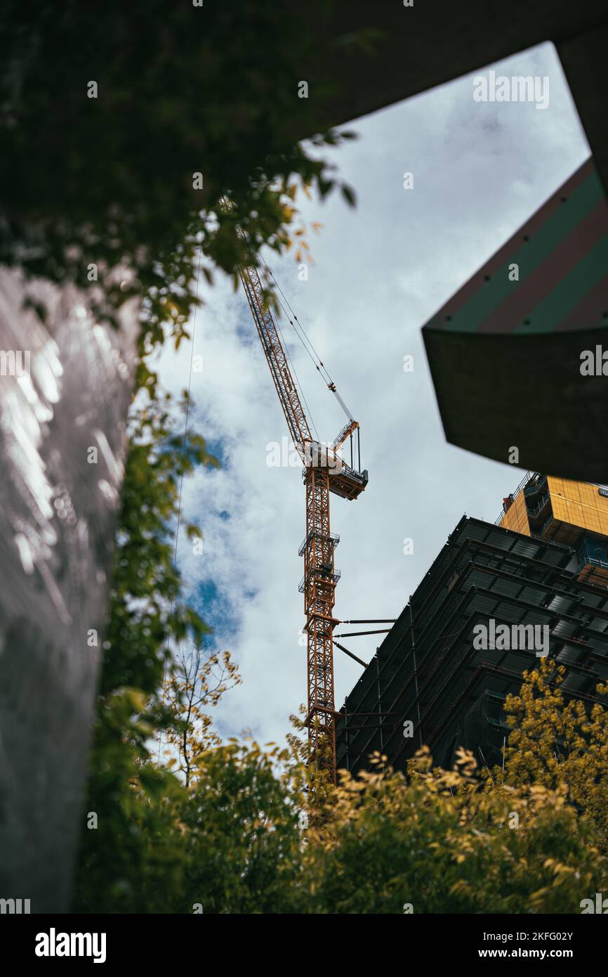 The low-angle vertical shot of a crane working at the construction site ...