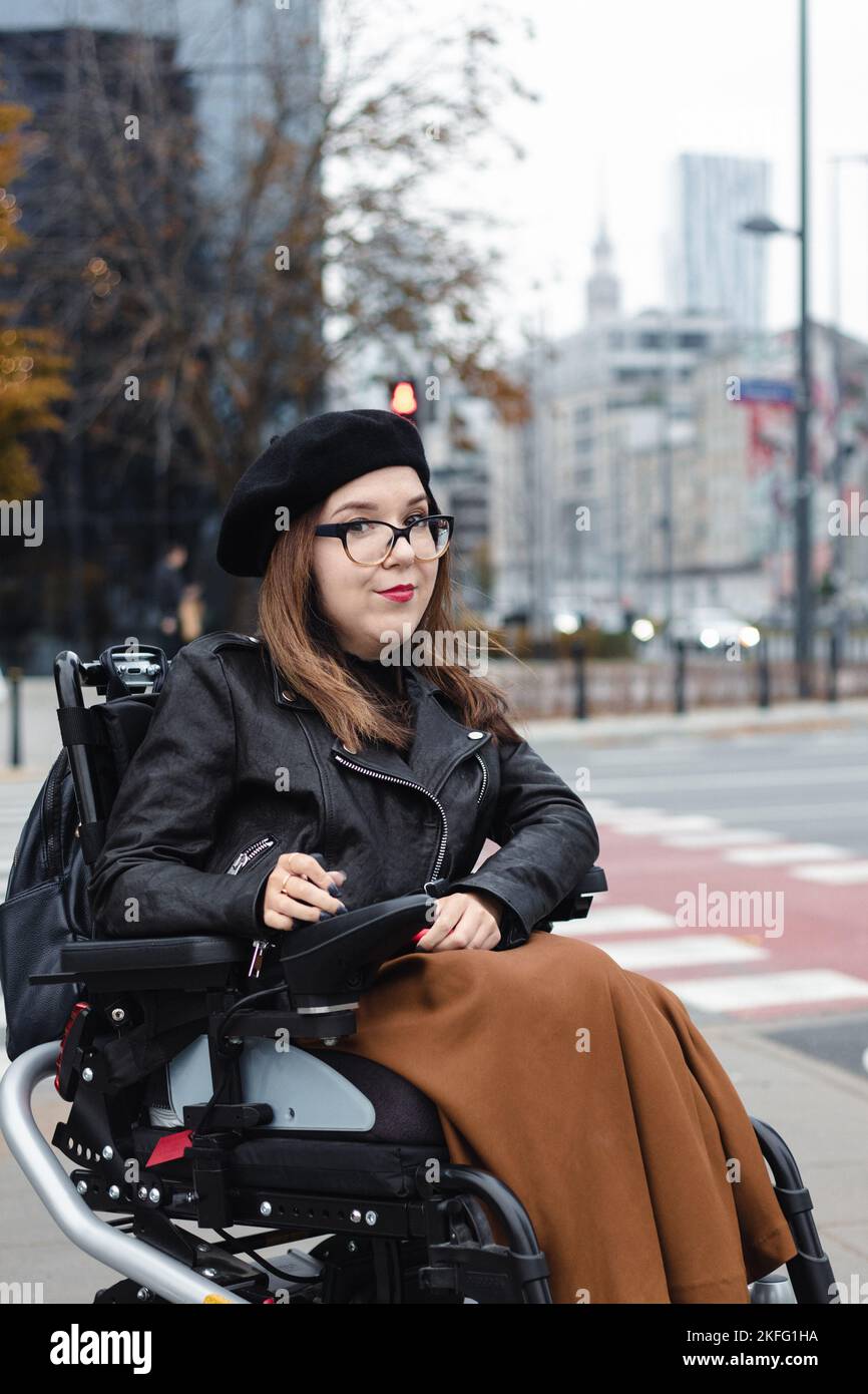 Brunette woman sitting in wheelchair on city street Stock Photo - Alamy