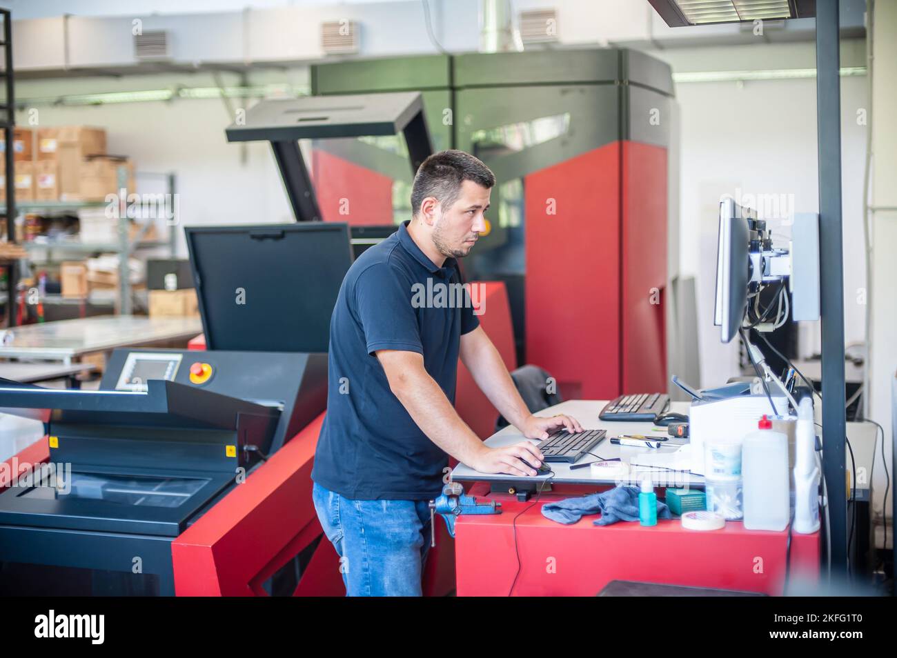 Professional worker with modern big offset printing machine in print ...