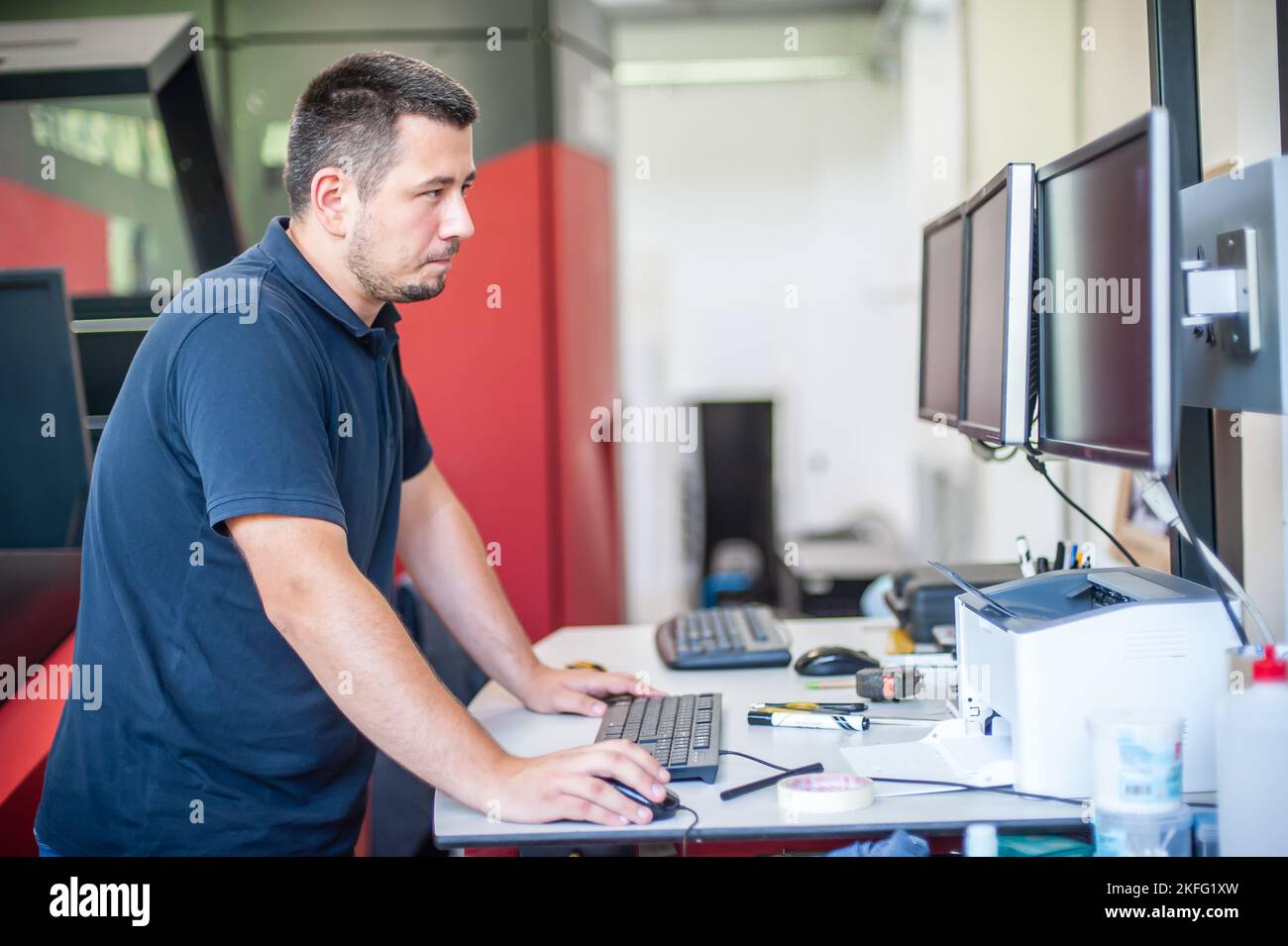 Professional worker with modern big offset printing machine in print ...