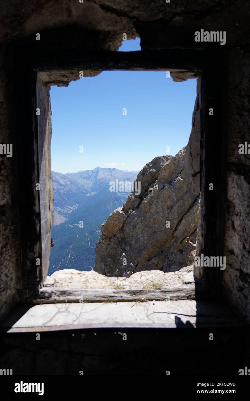 A vertical shot of a cliff from a window frame. Inside ruins of ...