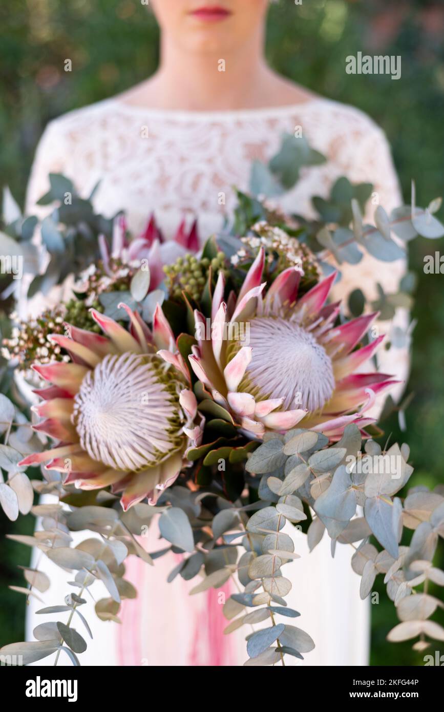 A close up of a bride holding her bouquet of flowers in front of her on ...