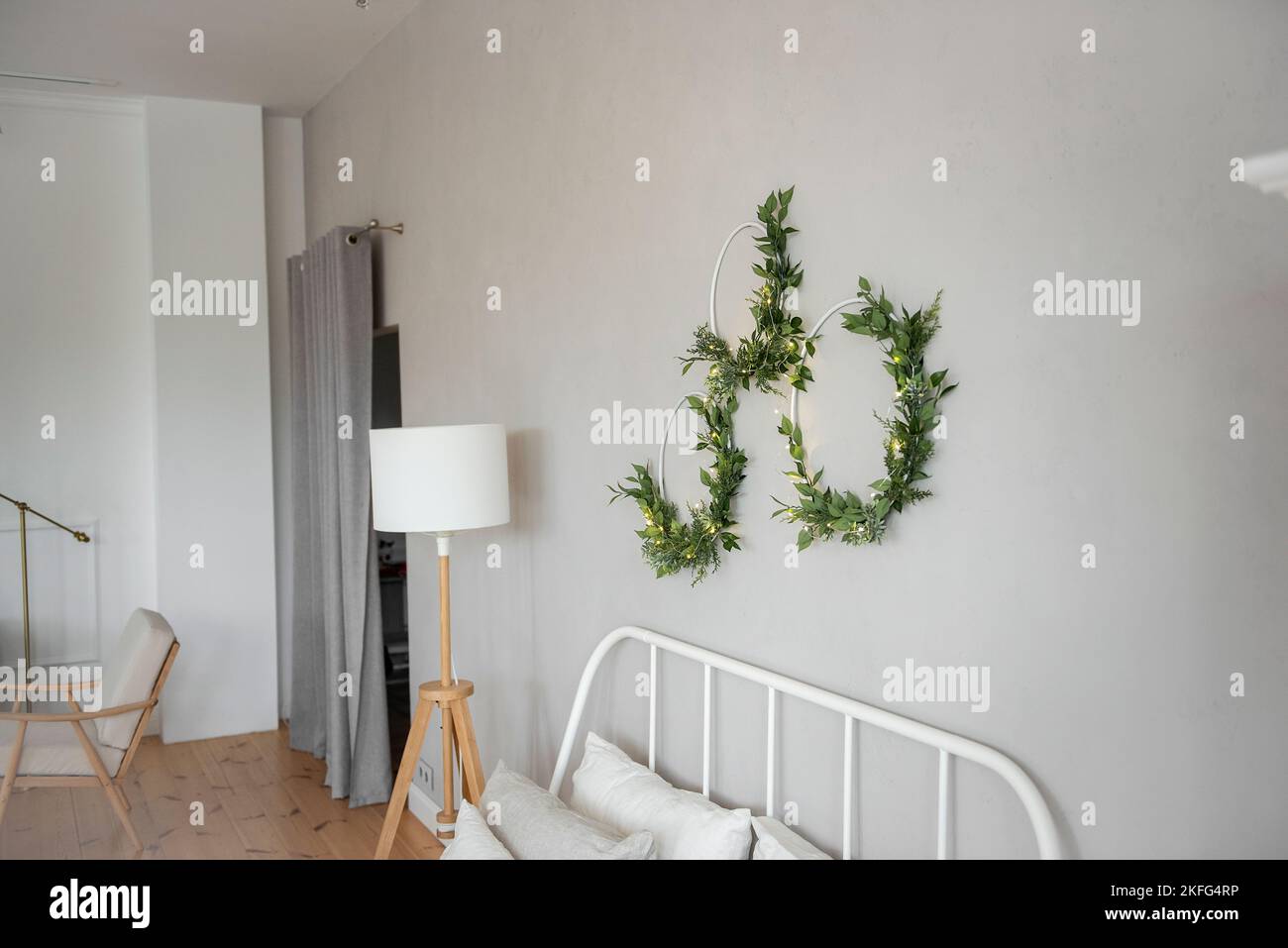 On gray concrete wall, there are three laconic, elegant, green wreaths ...