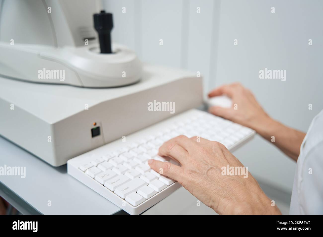 Close up photo of ophthalmologist typing on keyboards Stock Photo - Alamy