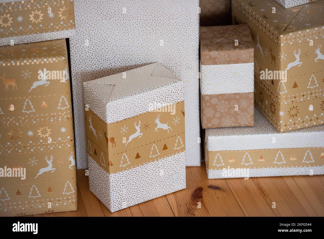 Wooden floor, laminate, boxes with gifts in white craft gold paper ...