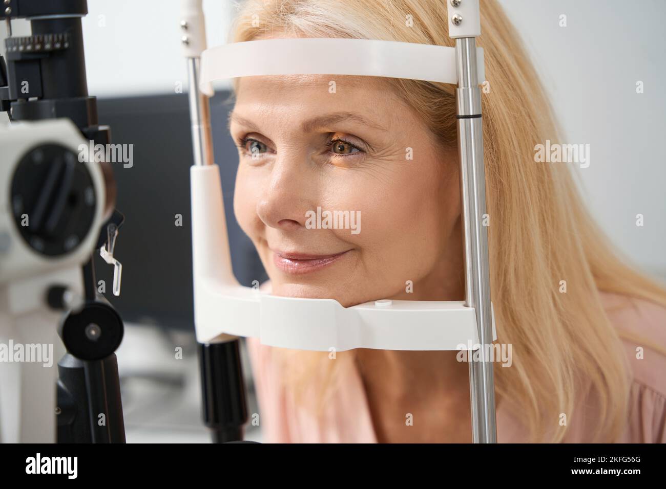 Adult female looking directly at eye tester Stock Photo - Alamy