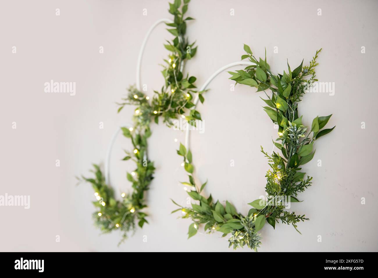 On gray concrete wall, there are three laconic, elegant, green wreaths ...