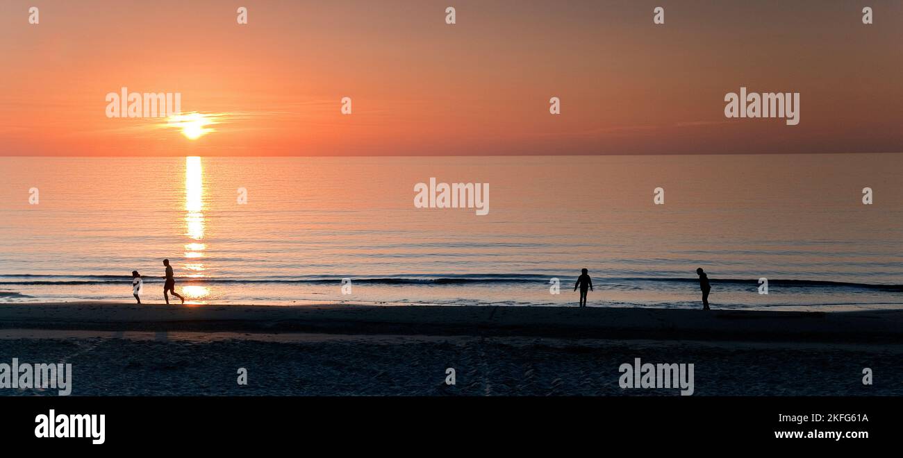 Photograph of people on beach with a summer sunset on the Irish Sea at ...