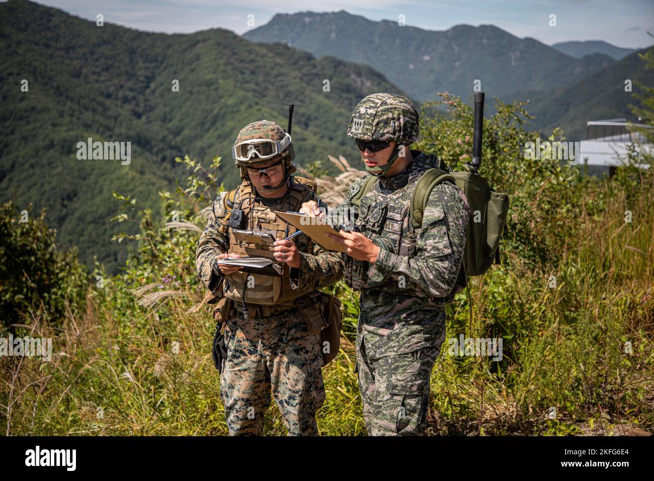 U.S. Marine Corps Maj. Robin Yi, the company air officer (left ...