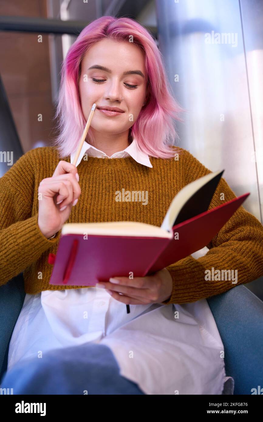 Pretty female is making notes to diary Stock Photo - Alamy