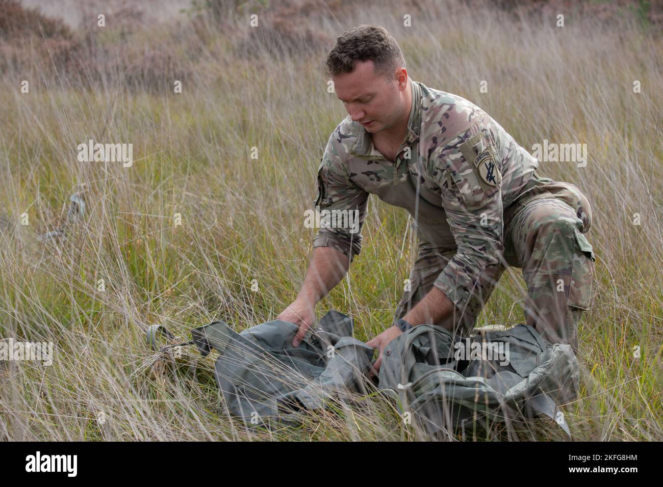 A U.S. Army Paratrooper gathers up his assigned parachute during ...