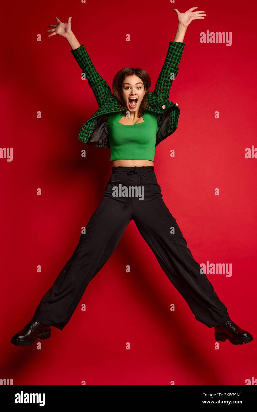 Portrait of young beautiful woman posing, jumping in excitement ...