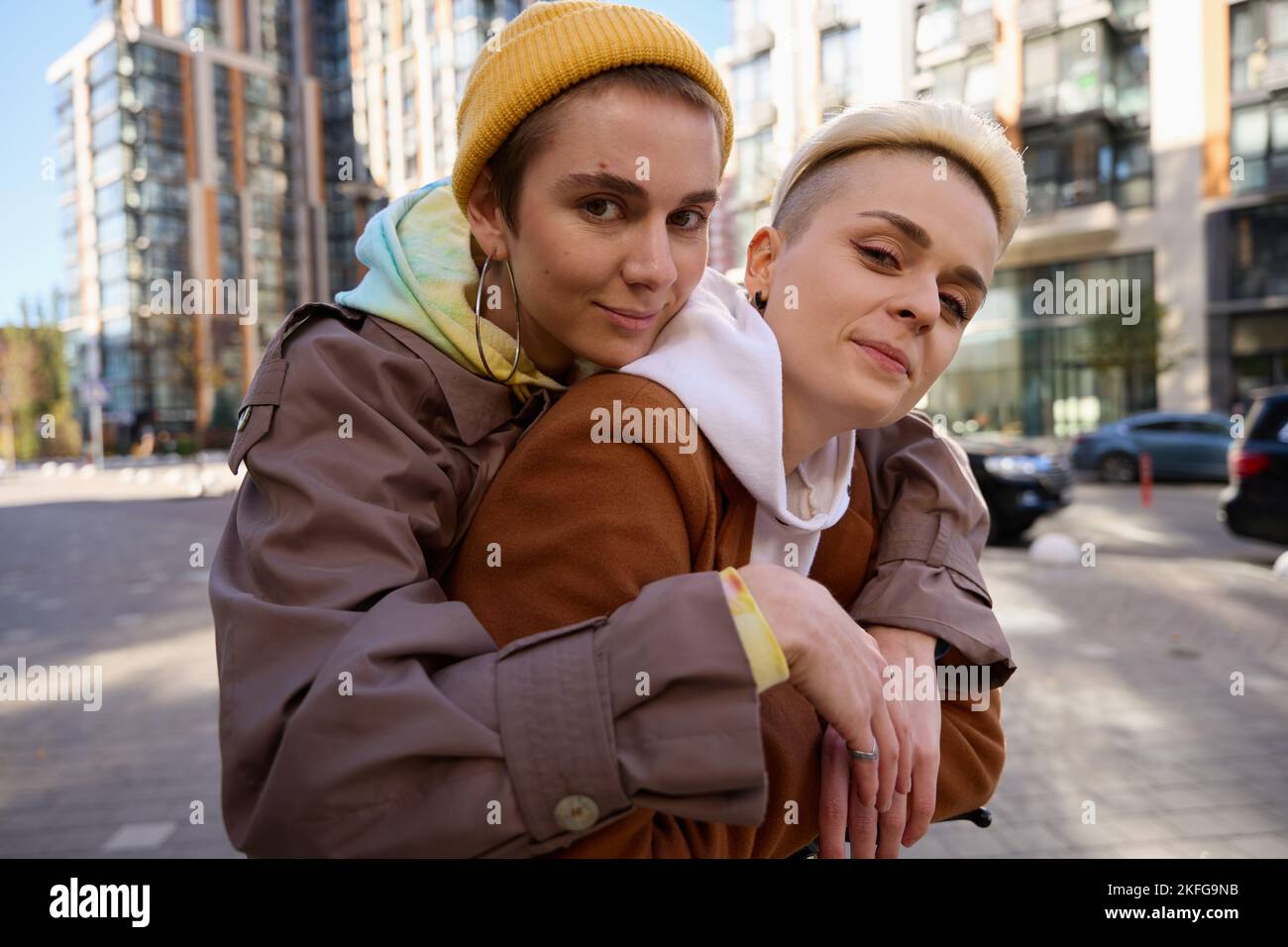 Two smiling women, lgbt couple, walking together in big city Stock ...