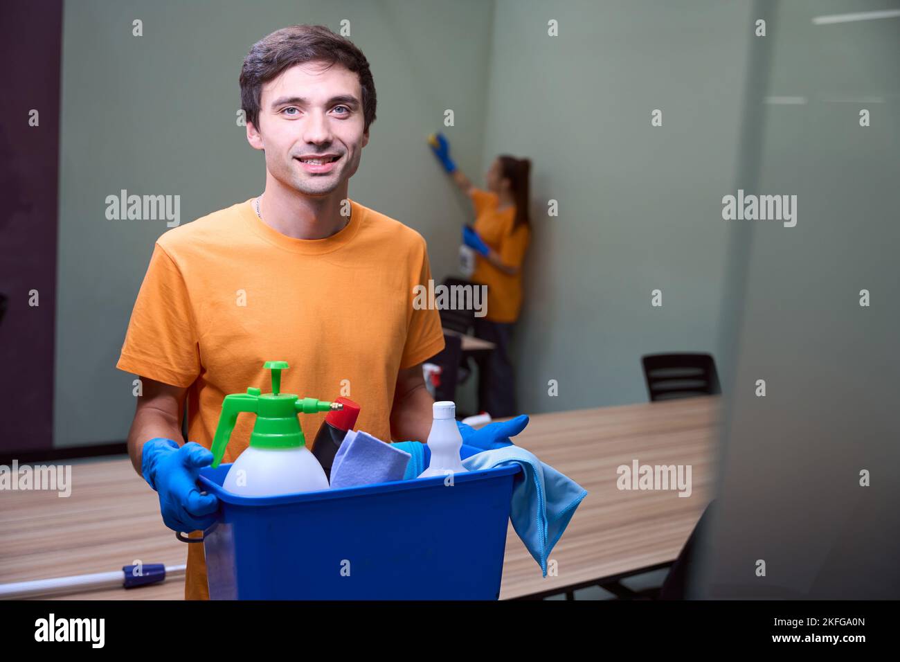 Professional cleaner demonstrating a box of different housecleaning ...