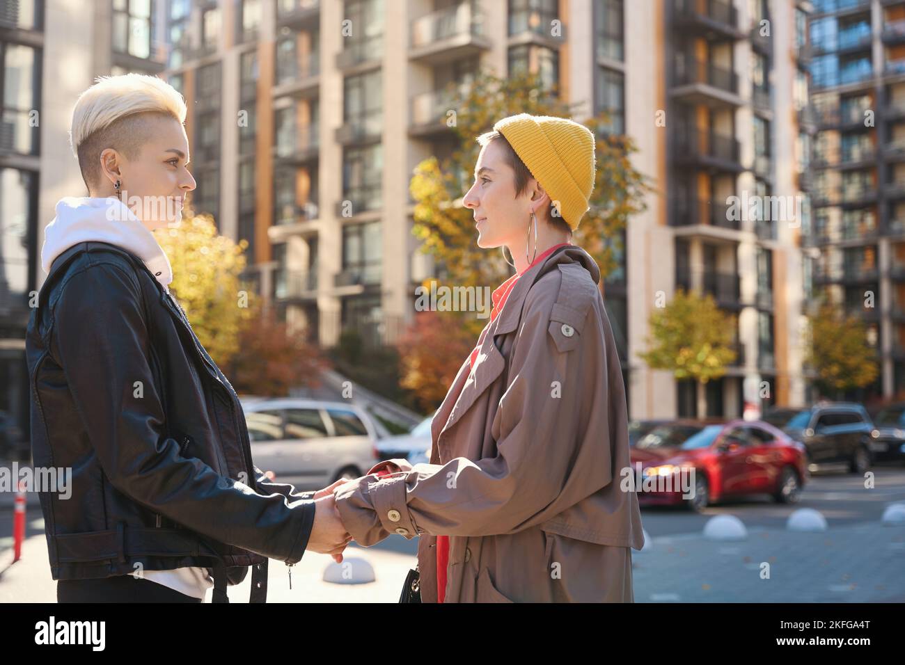 Girlfriends, LGBT couple, stand against backdrop of huge city buildings ...