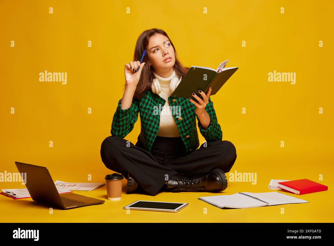 Portrait of young beautiful woman, student sitting on floor and doing ...