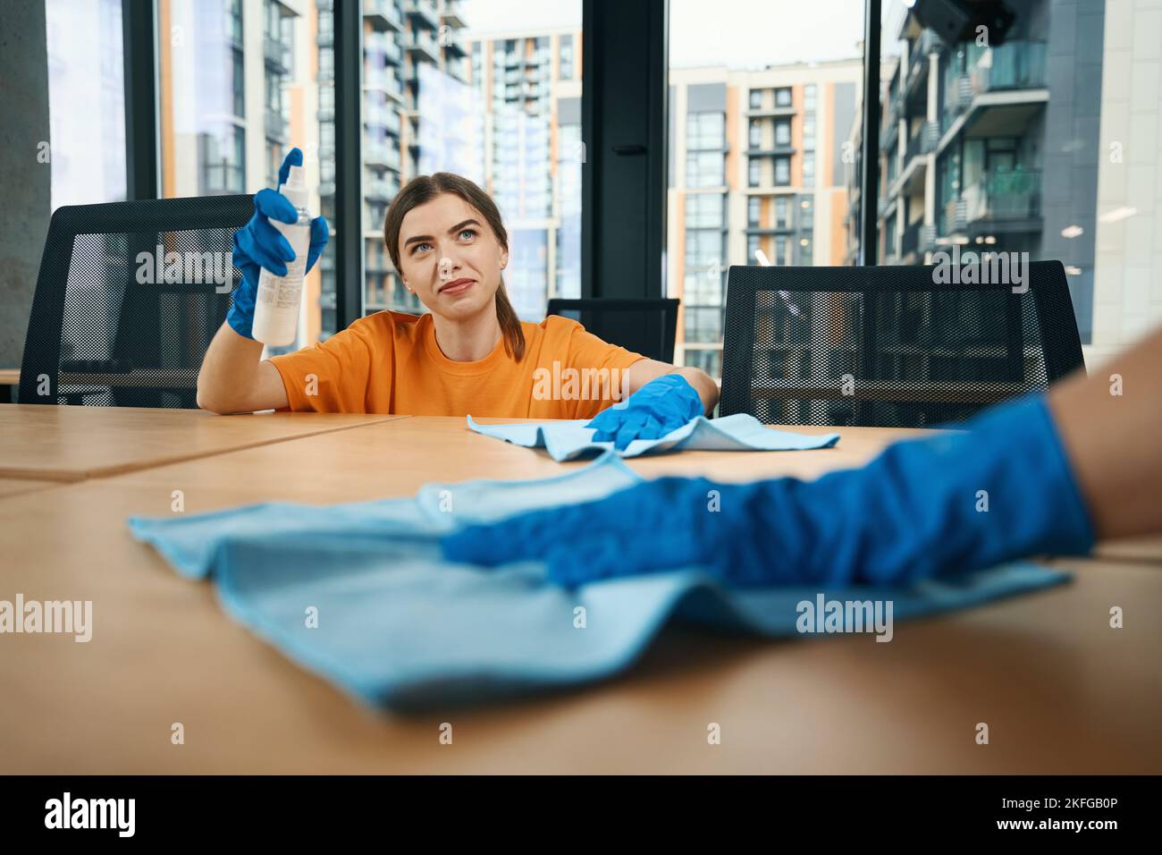 Cute cleaning company employees in rubber protective gloves disinfect ...