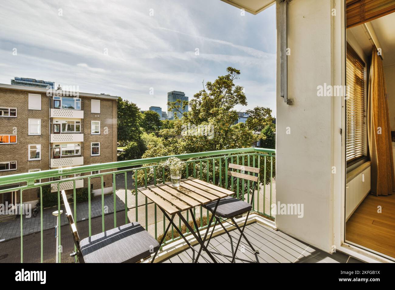 Narrow brick balcony with metal railings, wooden chair and door Stock ...