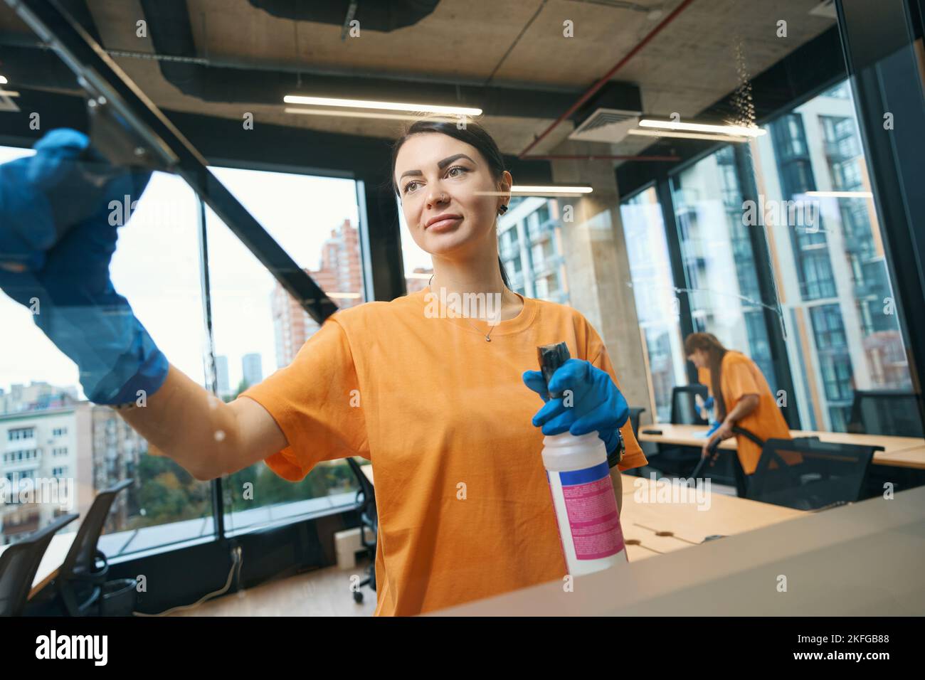 Cleaning service workers use special glass scraper, a vacuum cleaner ...