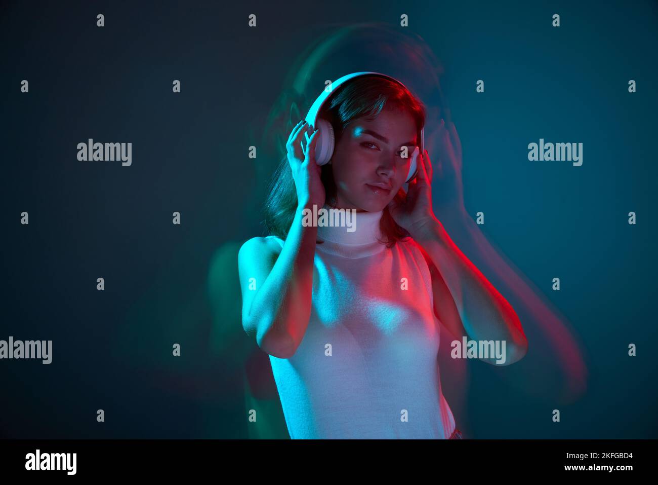 Portrait of young beautiful woman posing, listening to music in ...