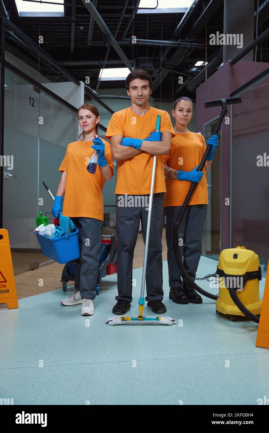 Cleaning company workers holding necessary housecleaning equipment ...