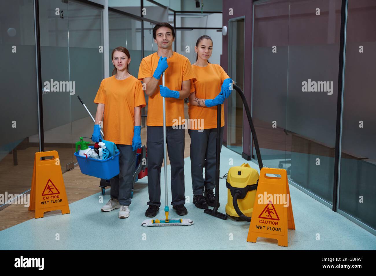 Young workers of cleaning company standing together with tools Stock ...