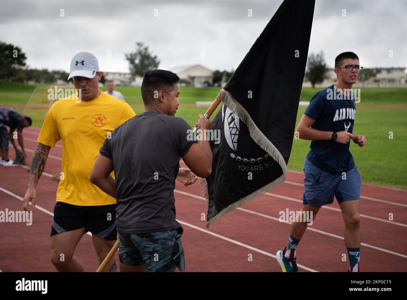 Participants pass the guidon during the POW/MIA run at Kadena Air Base ...