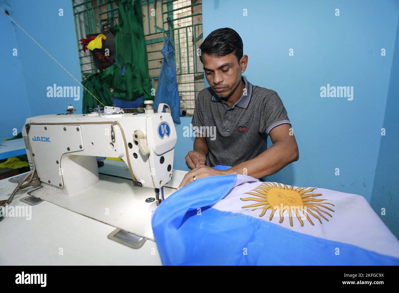 A Bangladeshi worker sewing flags for FIFA World Cup football playing ...