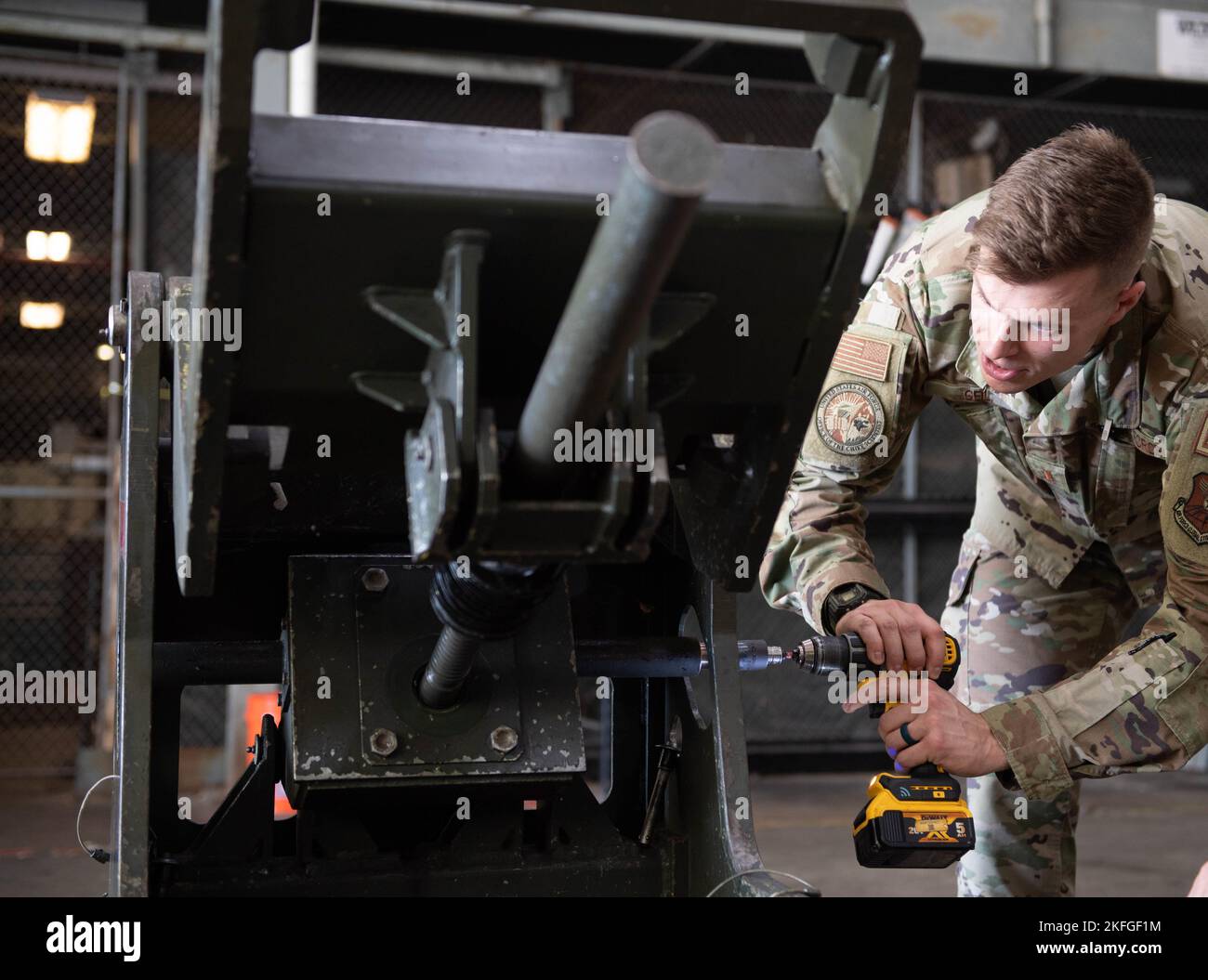 2nd Lt. Jacob Geil, Project Arc test engineer, uses a power drill to ...