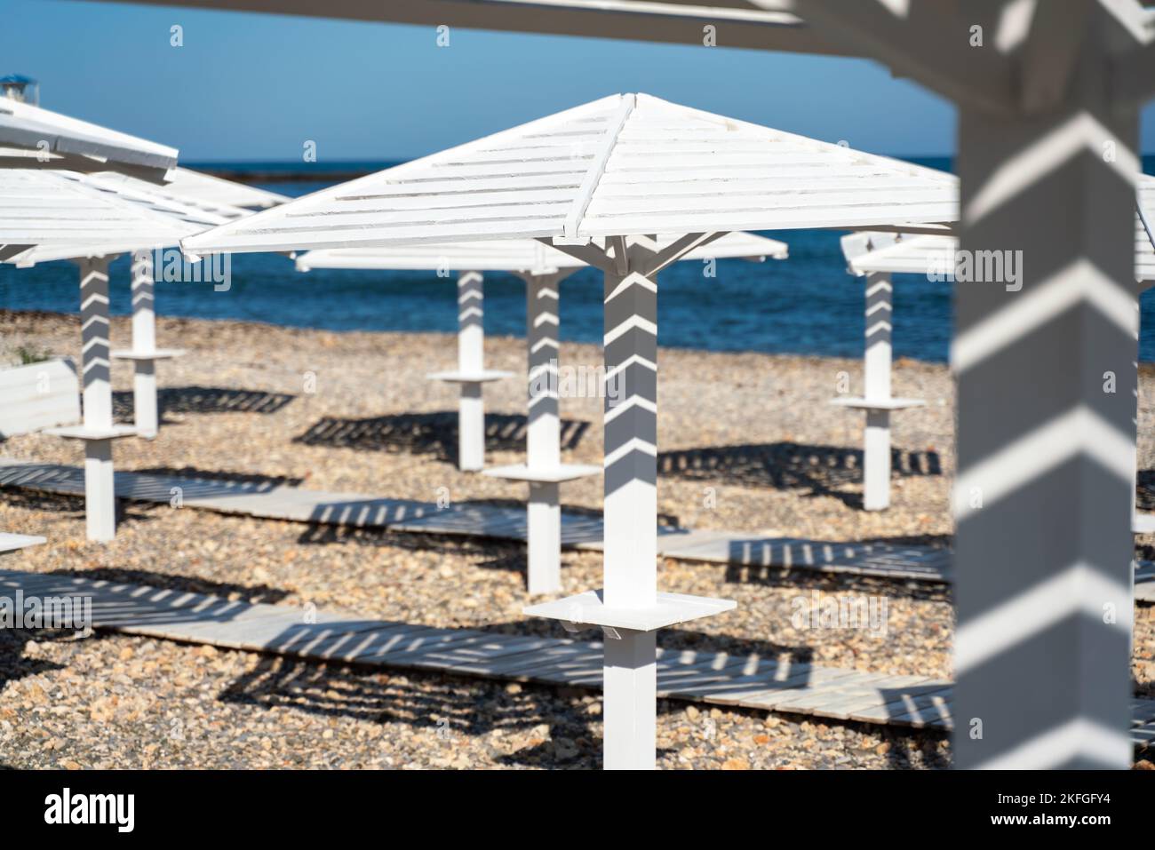 Rows of wooden umbrellas from the sun on the seashore in the morning ...